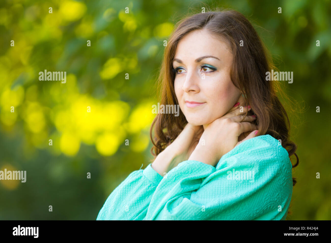 Portrait of a girl hugging his neck on a background of green foliage ...