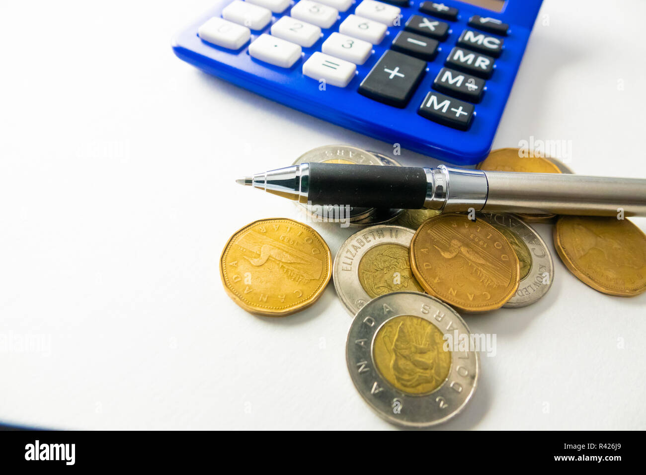 Silver ballpoint pen with blue pocket calculator and coins Stock Photo ...