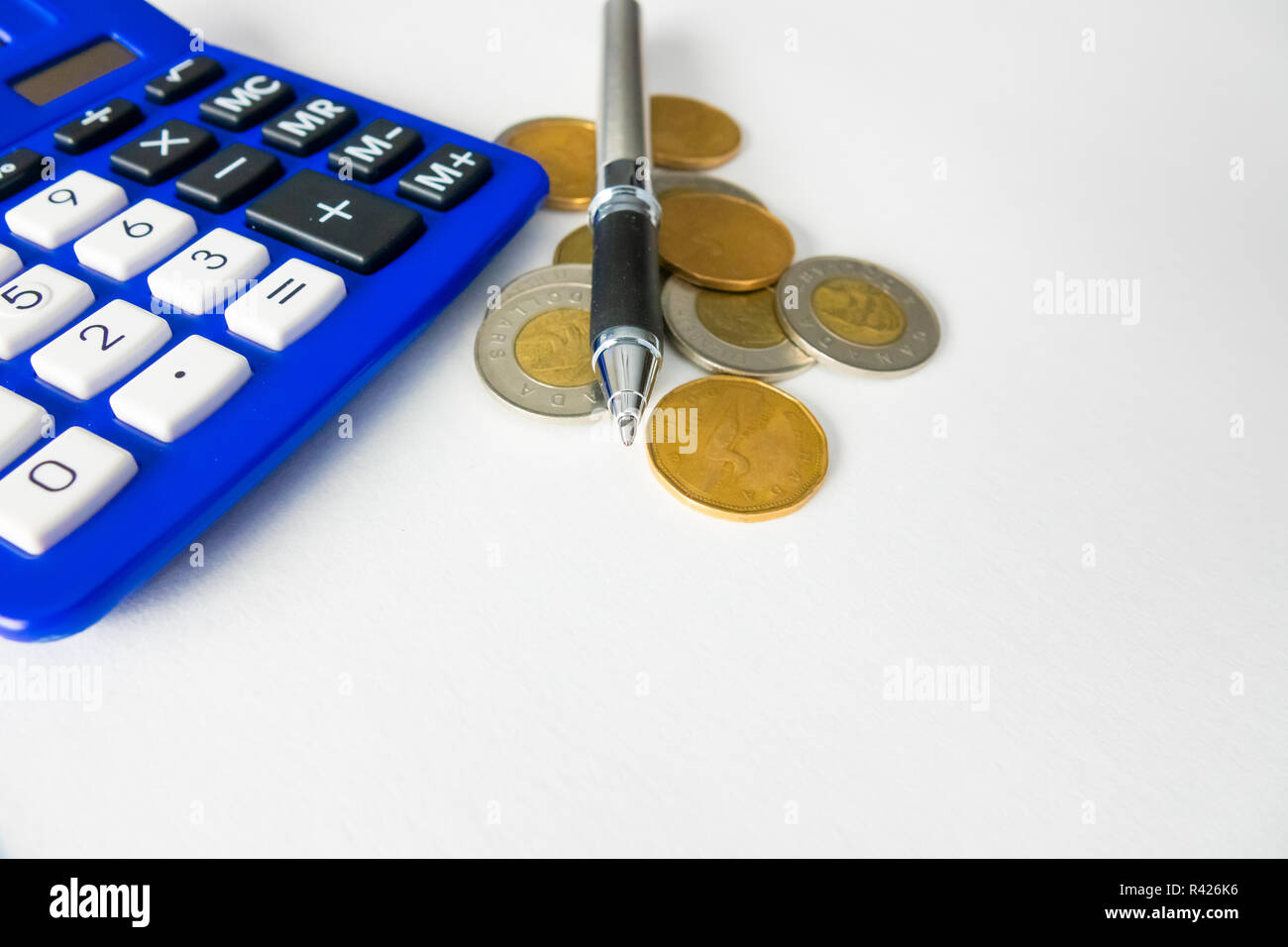 Silver ballpoint pen with blue pocket calculator and coins Stock Photo ...
