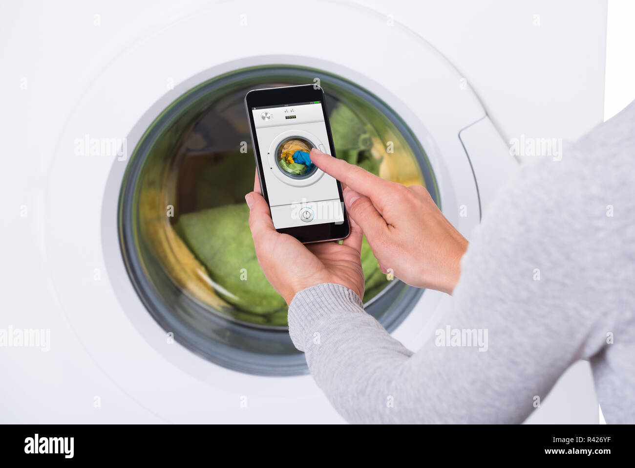 Woman Using Mobile Phone To Operate Washing Machine Stock Photo - Alamy