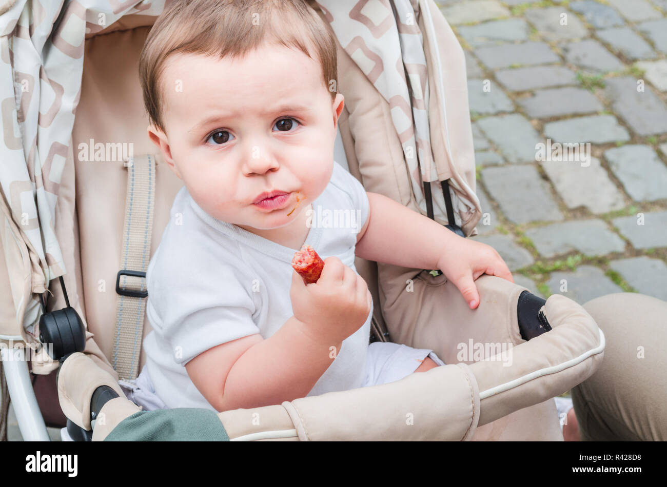 child in stroller eating a sausage Stock Photo - Alamy