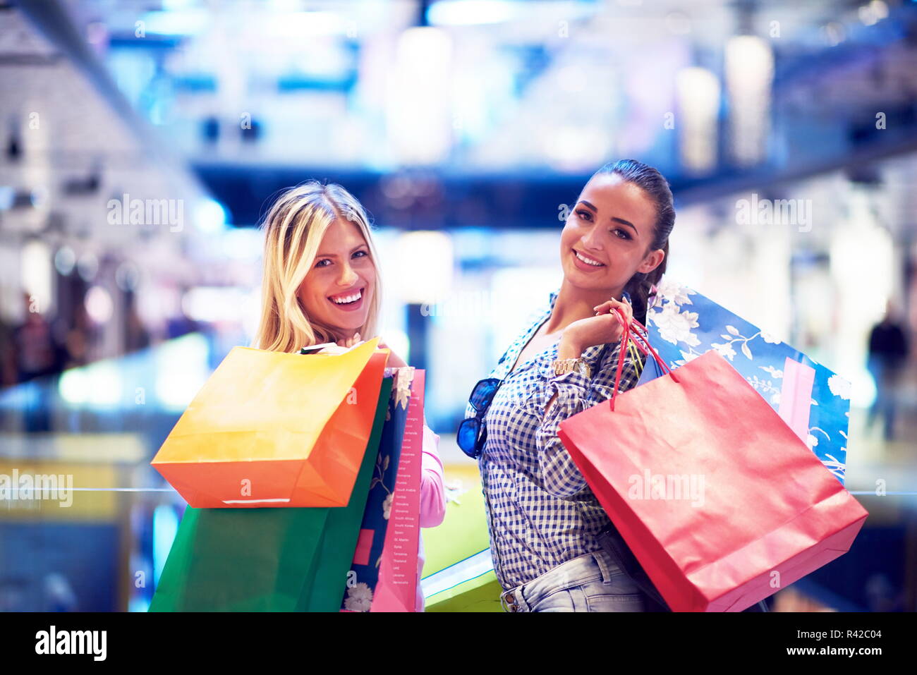 happy young girls in shopping mall Stock Photo - Alamy