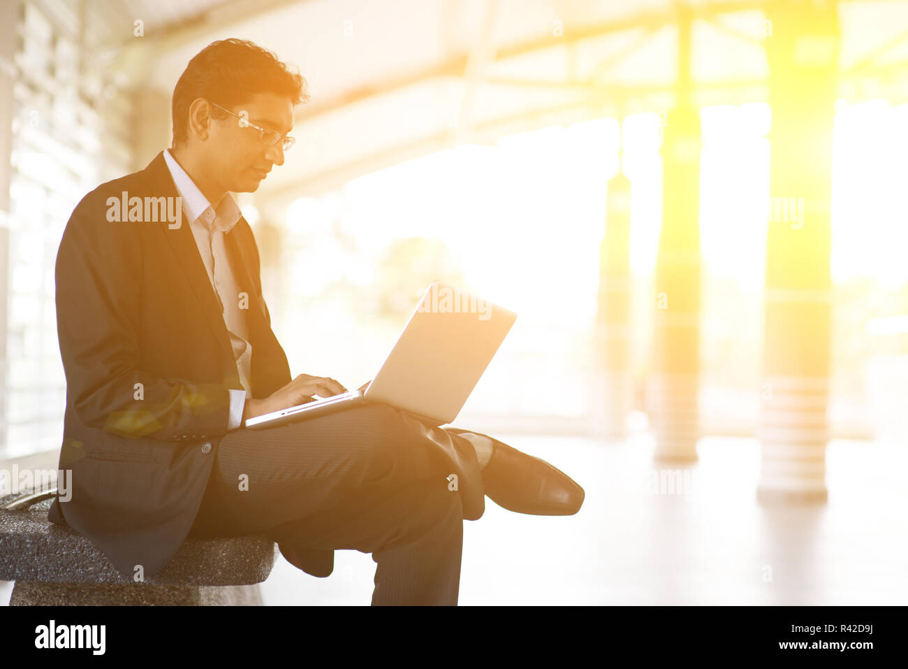 Indian businessman using laptop computer at railway station Stock Photo ...