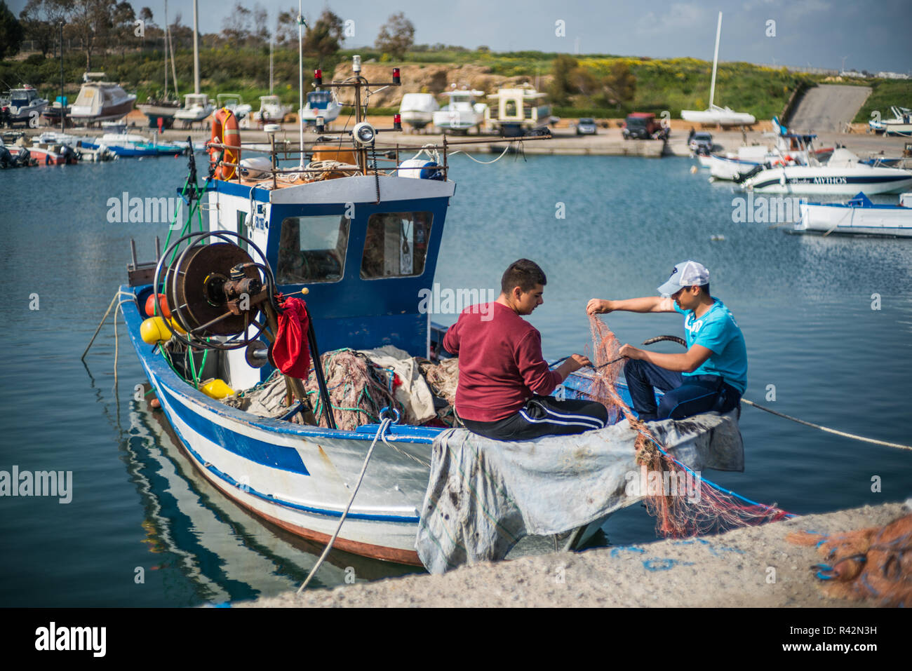 Two young fisherman in the boat, Le Castella, Italy, Europe Stock Photo ...