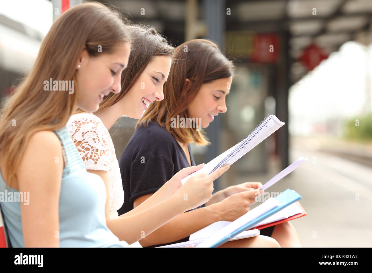 Three students studying and learning in a train station Stock Photo - Alamy