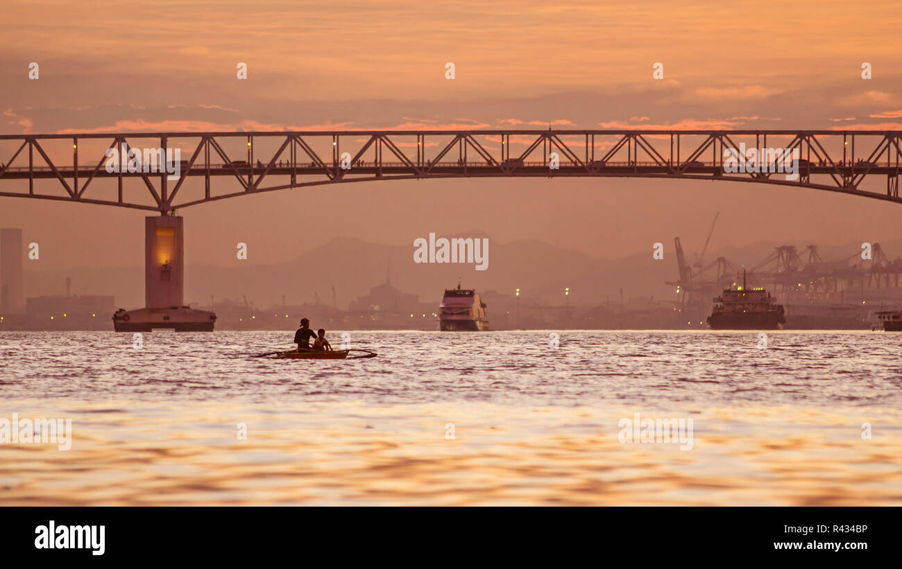 Traffic on bridge and sea crossing Mactan Bridge Cebu in misty dusk and ...
