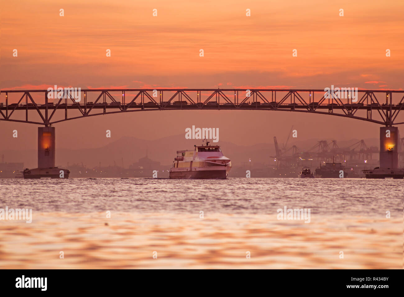 Traffic on bridge and sea crossing Mactan Bridge Cebu in misty dusk and ...