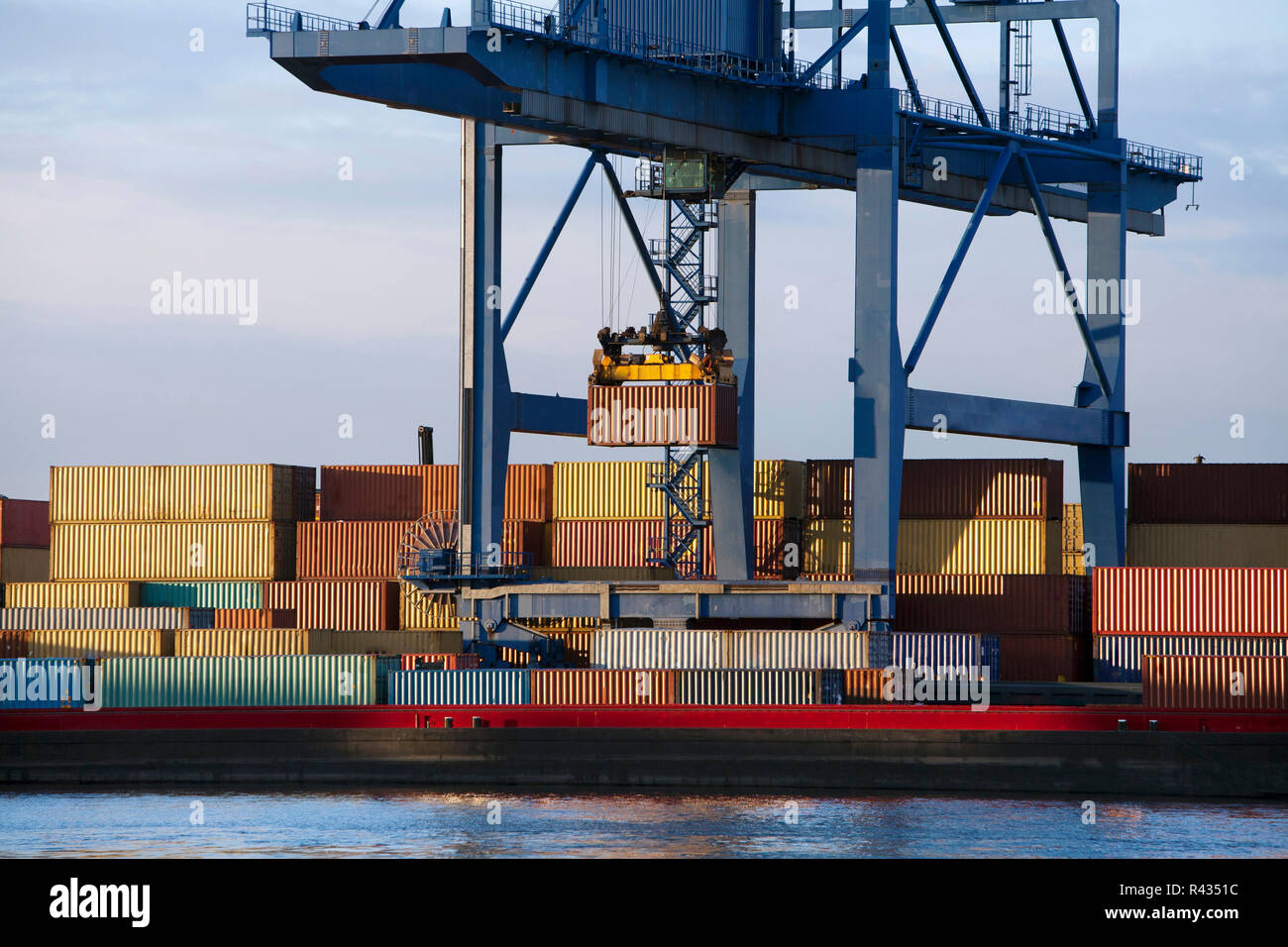 Loading containers in a barge Stock Photo - Alamy