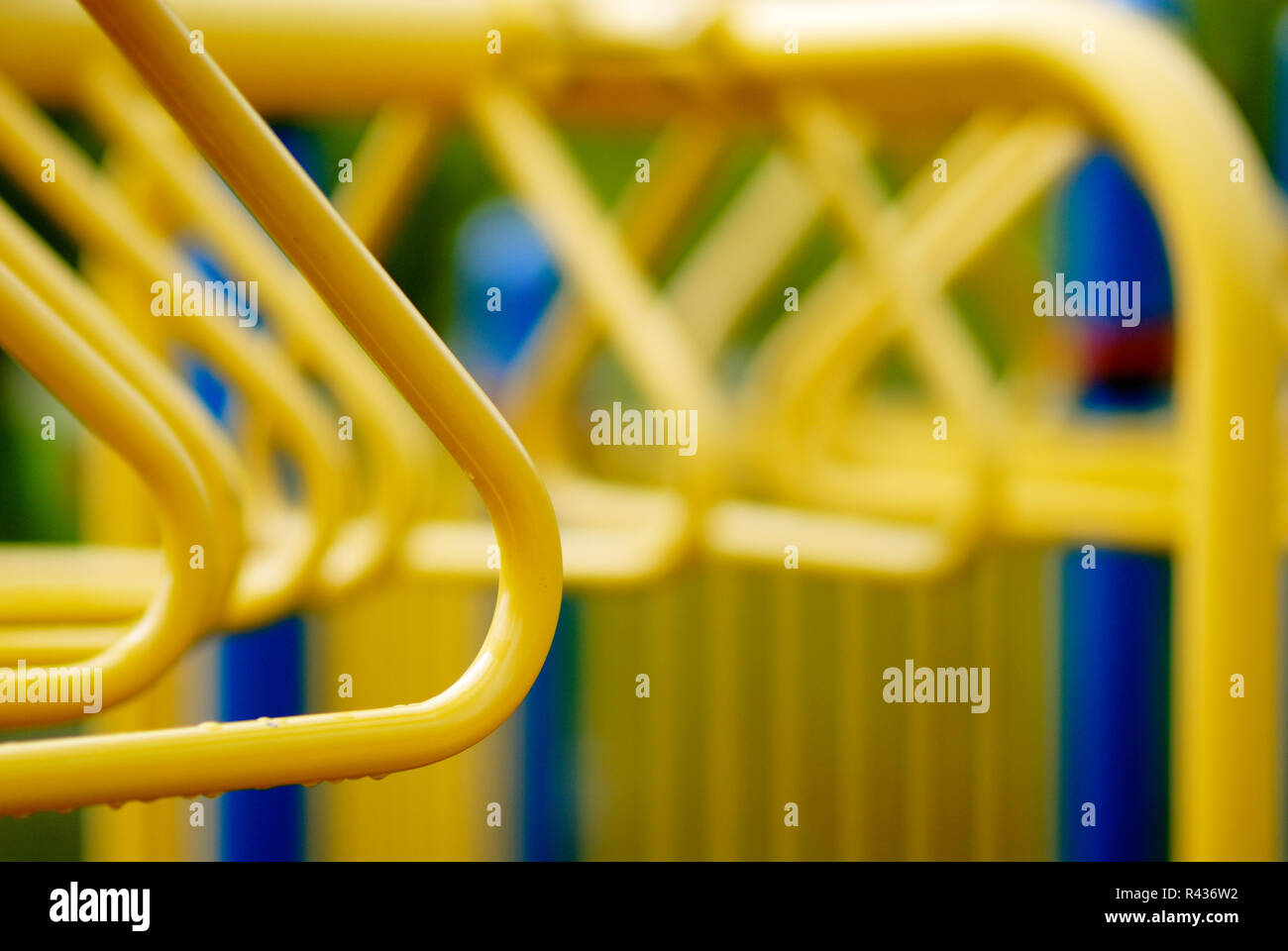 Yellow triangle bars in a curved row at a playground Stock Photo - Alamy