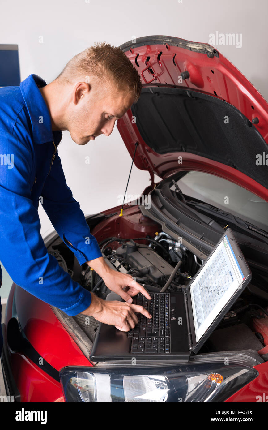 Mechanic Fixing Car With The Help Of Laptop Stock Photo - Alamy