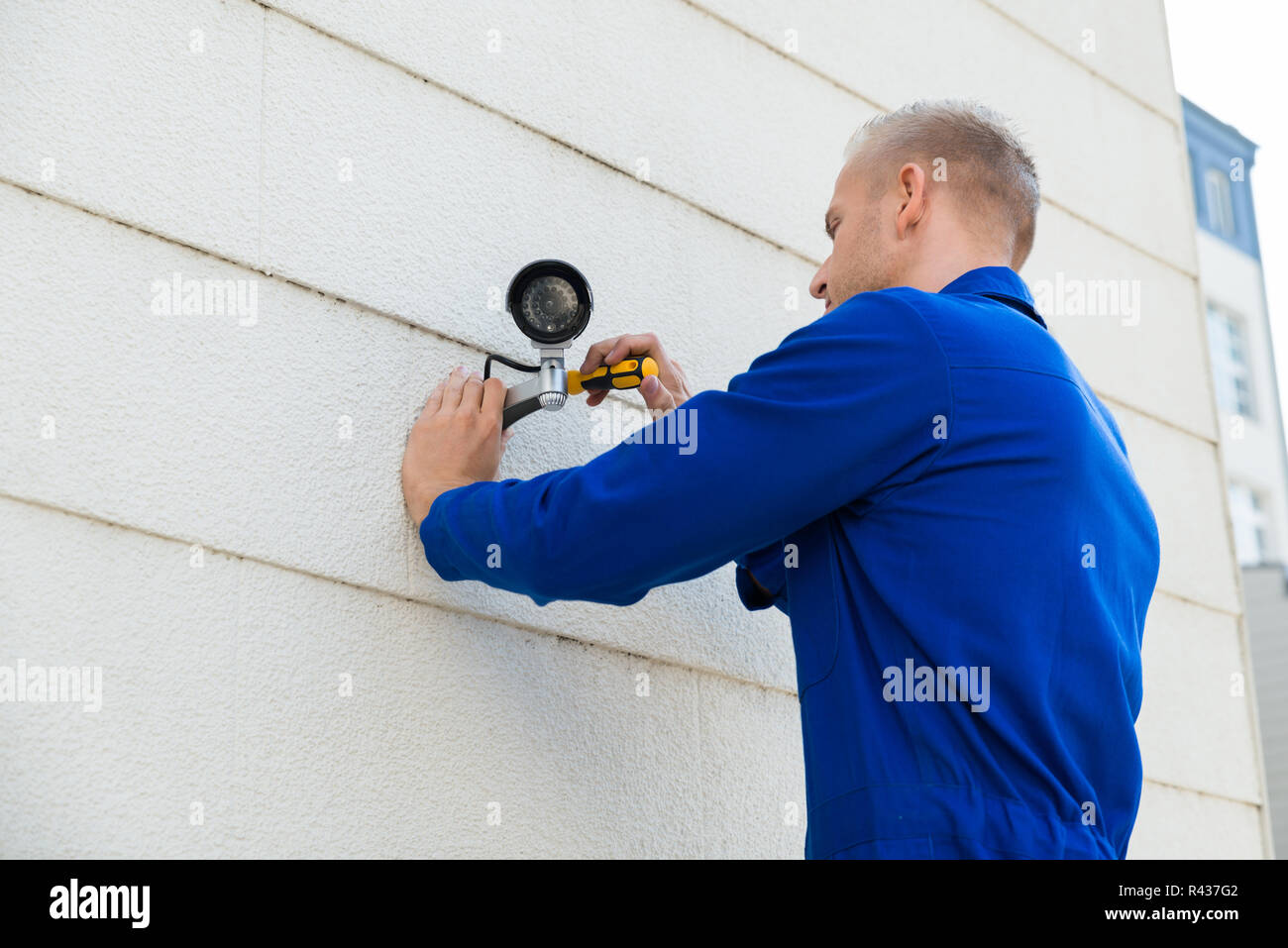 Technician Fixing Camera On Wall Stock Photo - Alamy