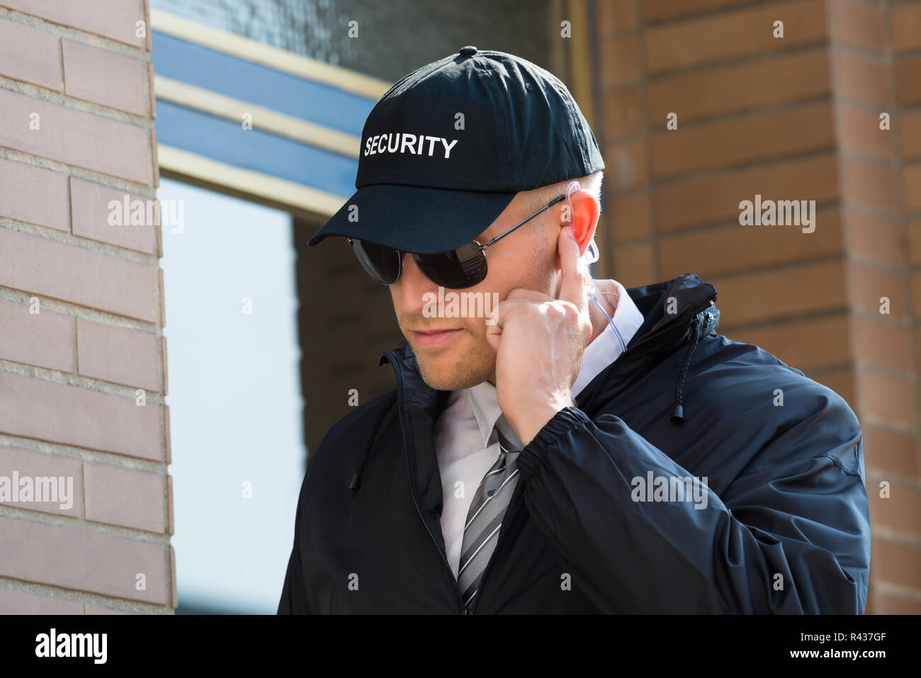 Young Security Guard Standing In Front Of The Entrance Stock Photo - Alamy
