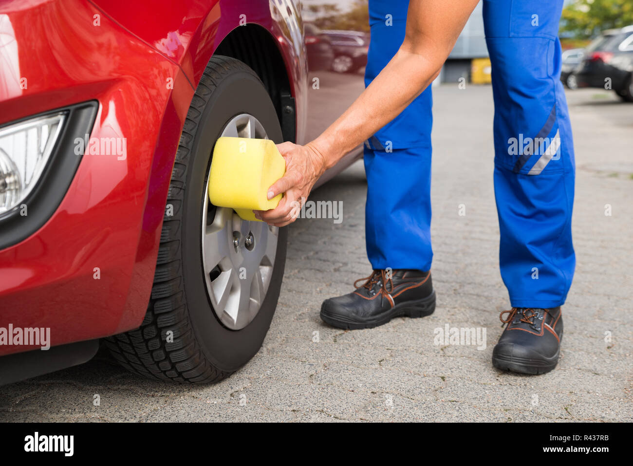 Worker Cleaning Car Wheel With Sponge Stock Photo - Alamy