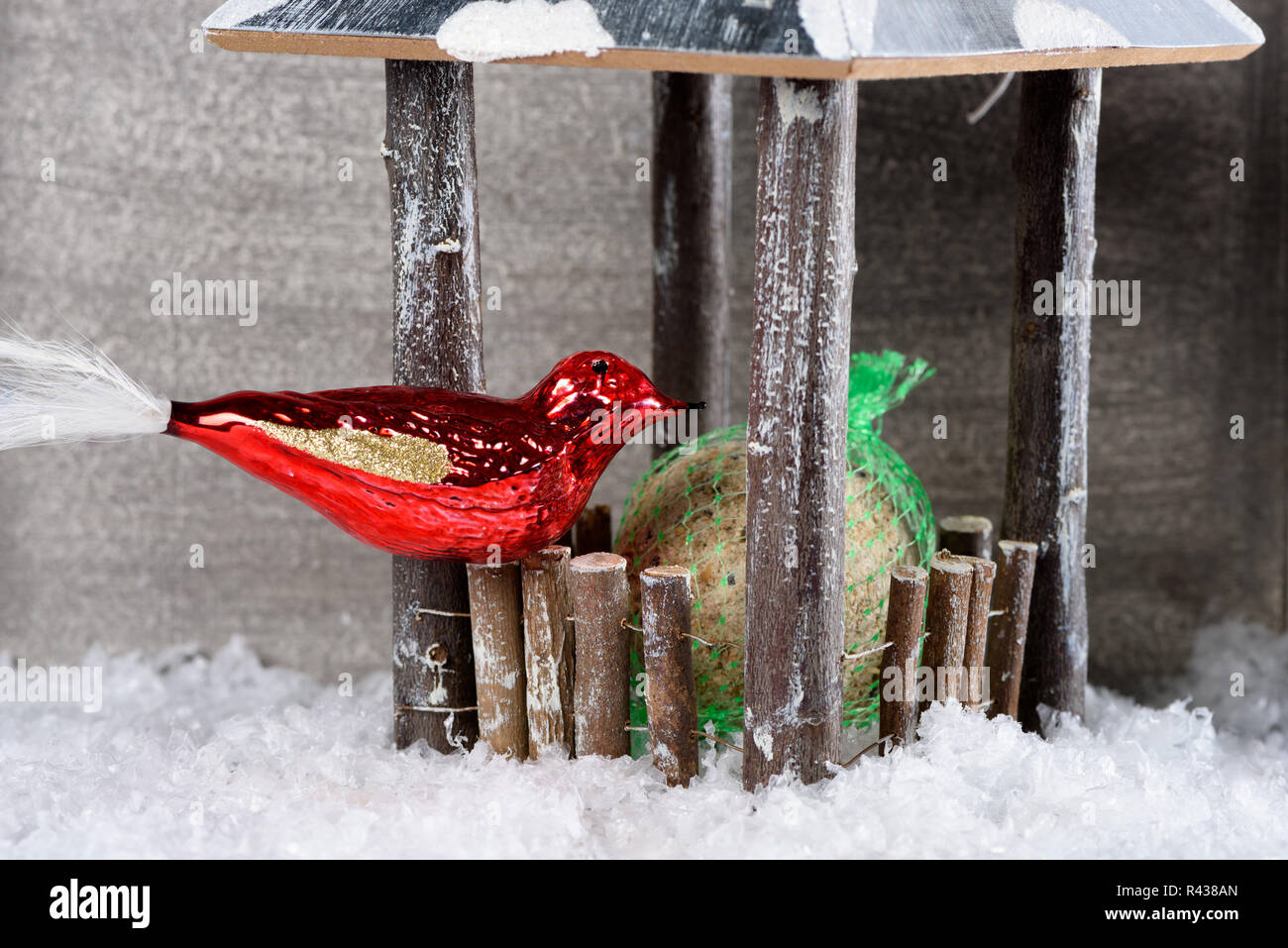 Red ornament bird finding seed in winter Stock Photo - Alamy