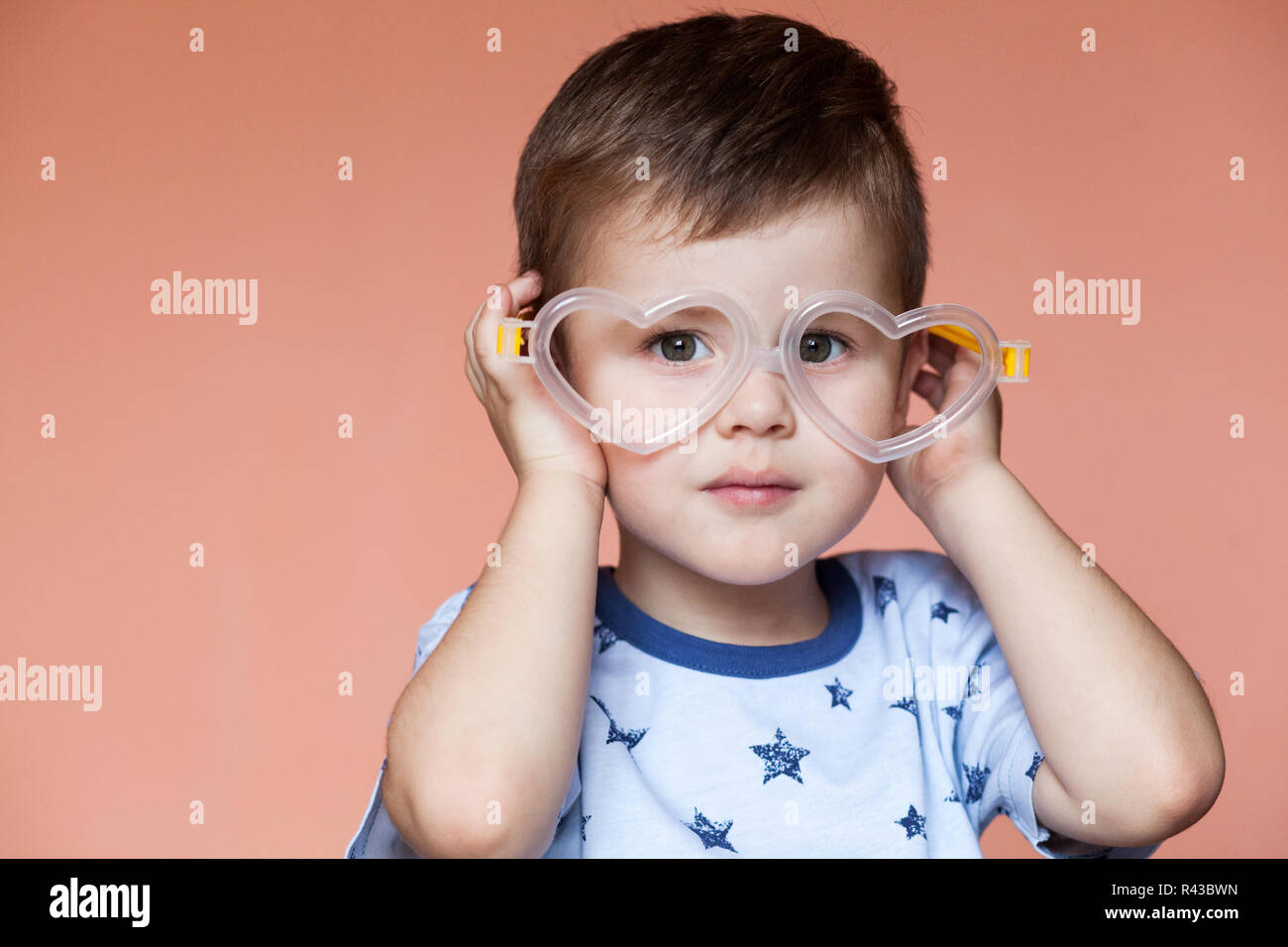 Portrait of cute little boy wearing heart shaped glasses Stock Photo ...