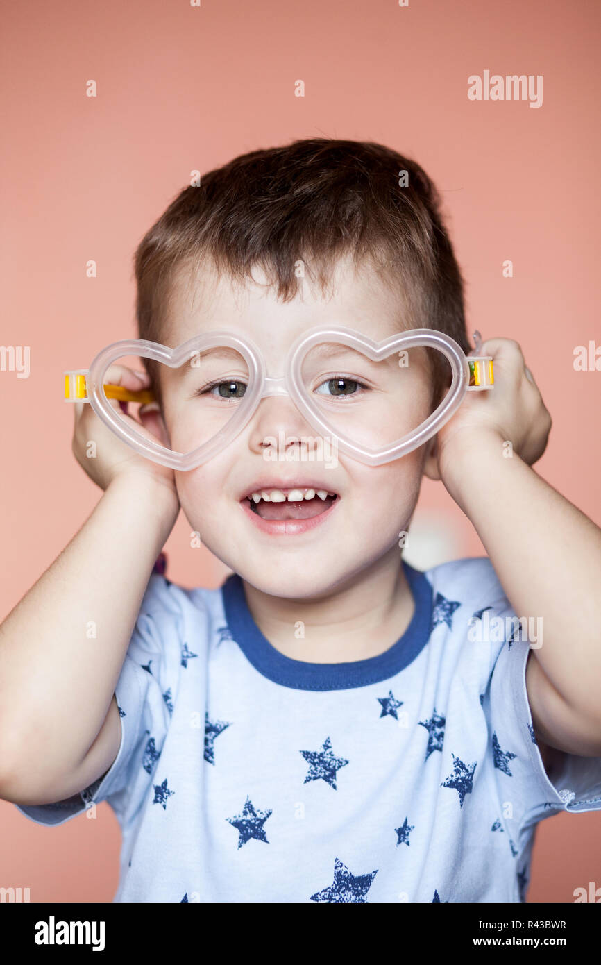 Portrait of cute little boy wearing heart shaped glasses Stock Photo ...