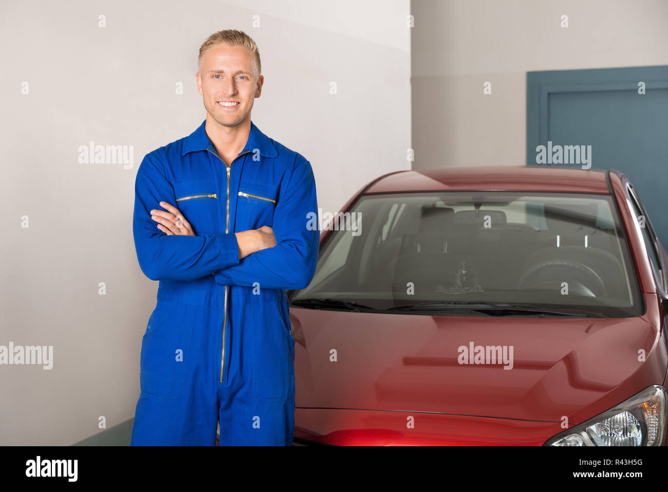 Mechanic Standing In Front Of Car With Folded Hands Stock Photo - Alamy