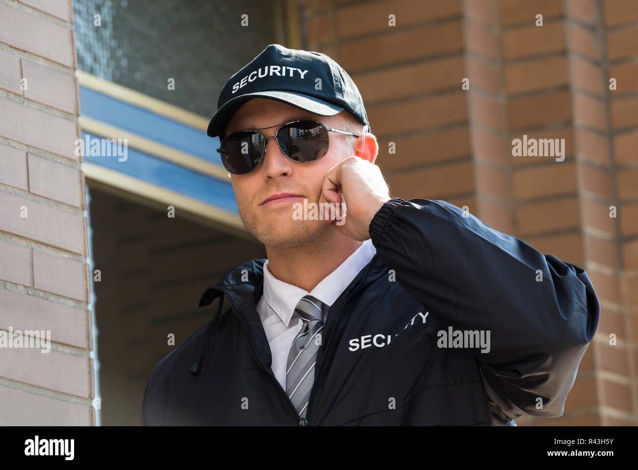 Young Security Guard Standing In Front Of The Entrance Stock Photo - Alamy