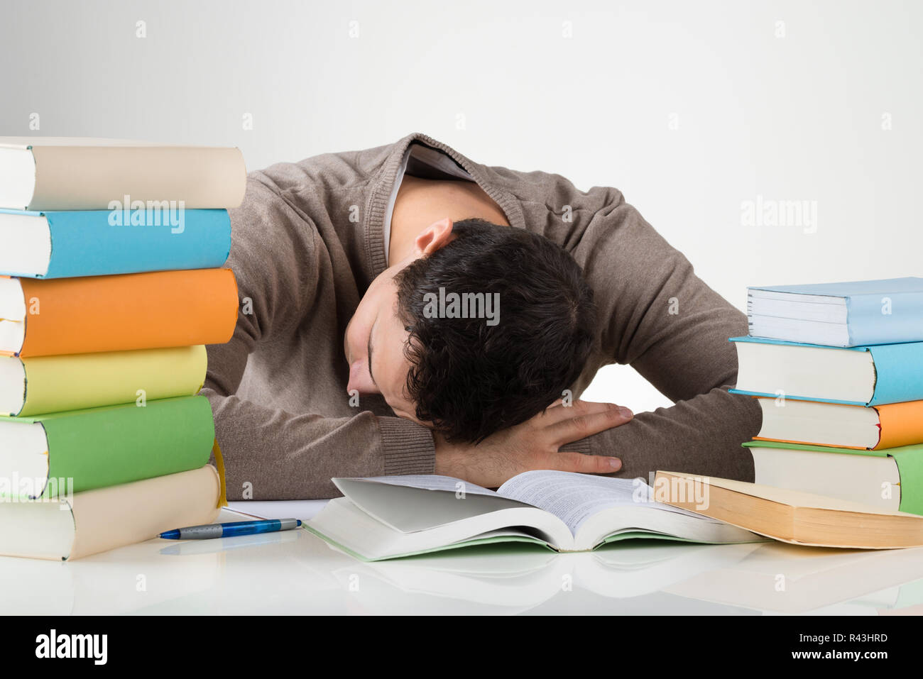 Tired Student Leaning On Desk While Studying Stock Photo - Alamy