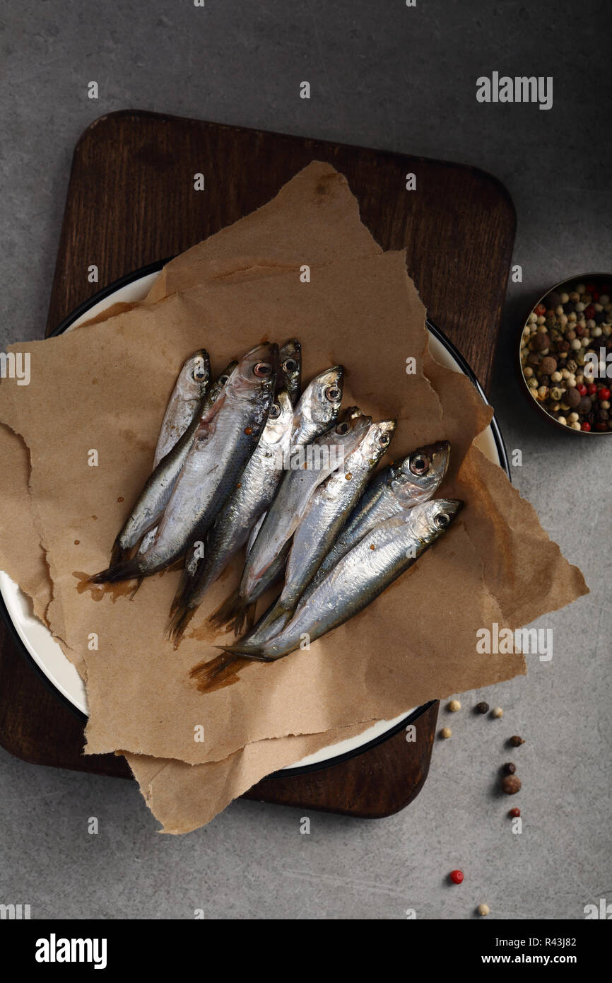 Salted and spicy sprats fish on plate Stock Photo - Alamy
