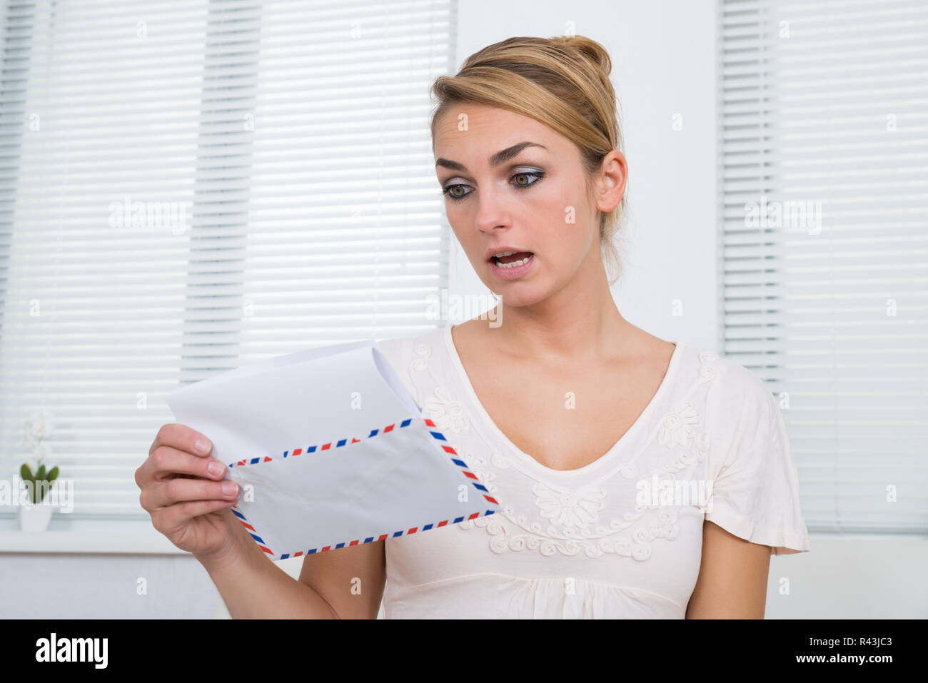 Shocked Woman Reading Letter At Home Stock Photo - Alamy