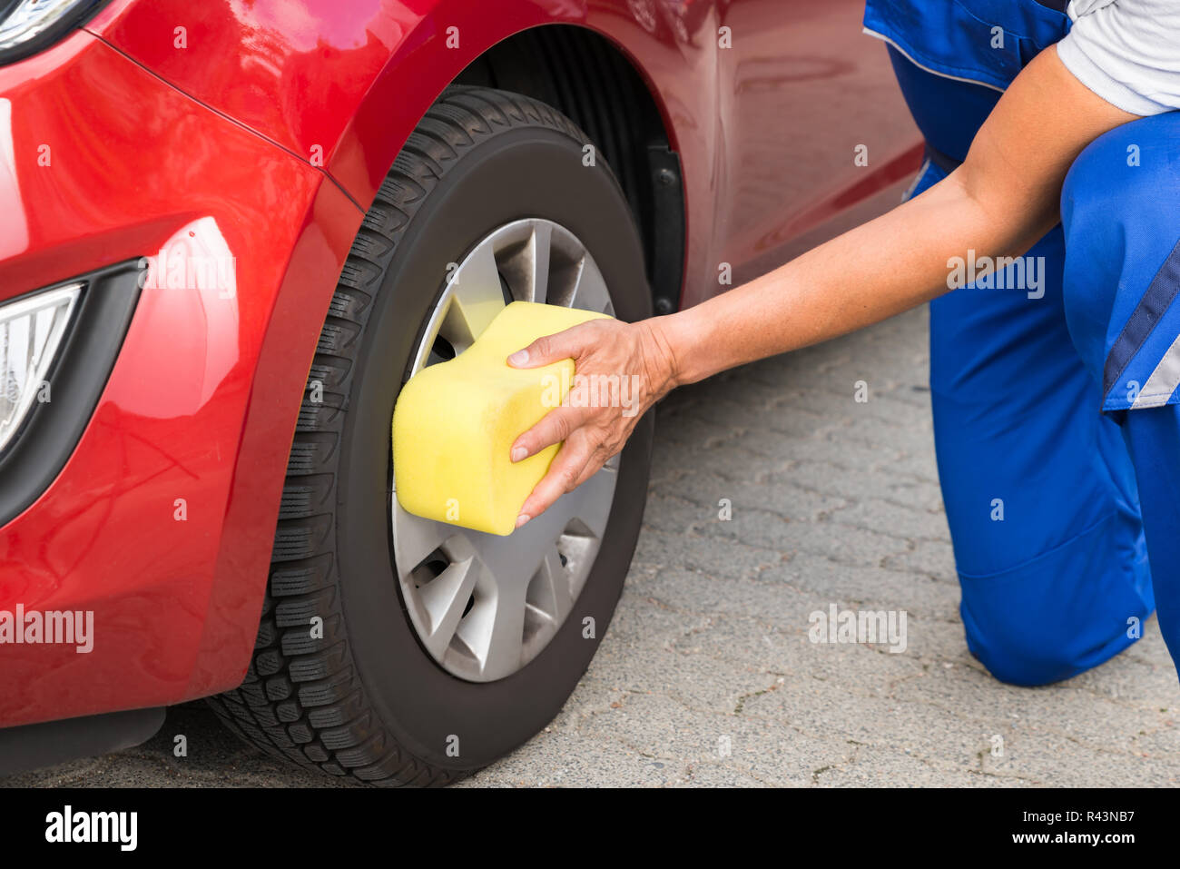 Worker Cleaning Car Wheel With Sponge Stock Photo - Alamy