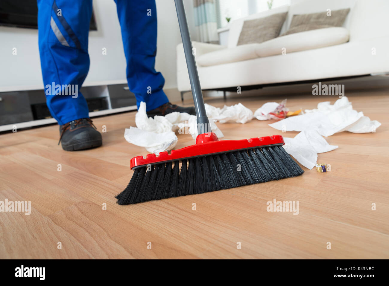 Janitor Sweeping Crumpled Papers On Floor Stock Photo - Alamy