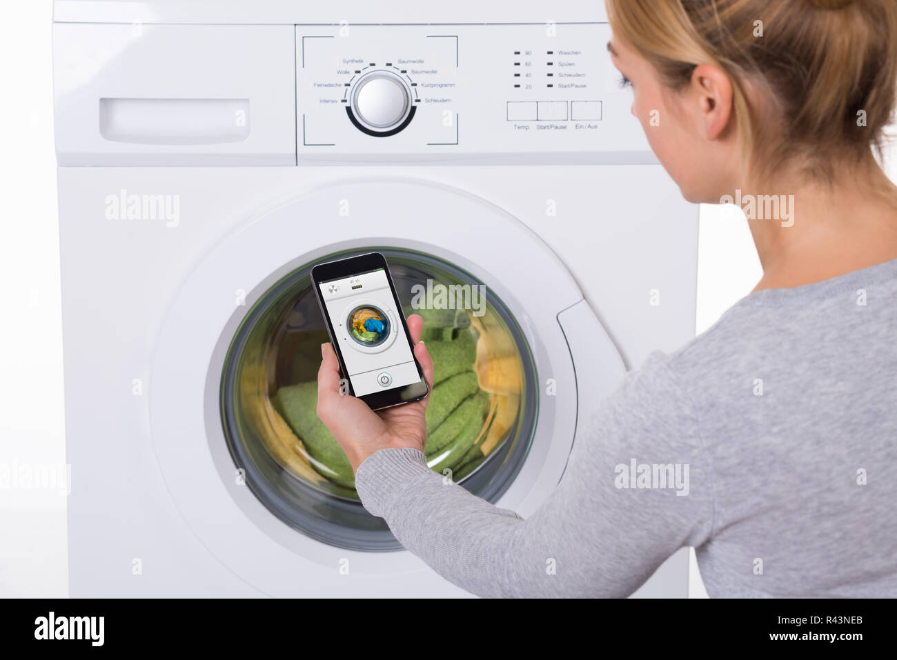Woman Using Mobile Phone To Operate Washing Machine Stock Photo - Alamy
