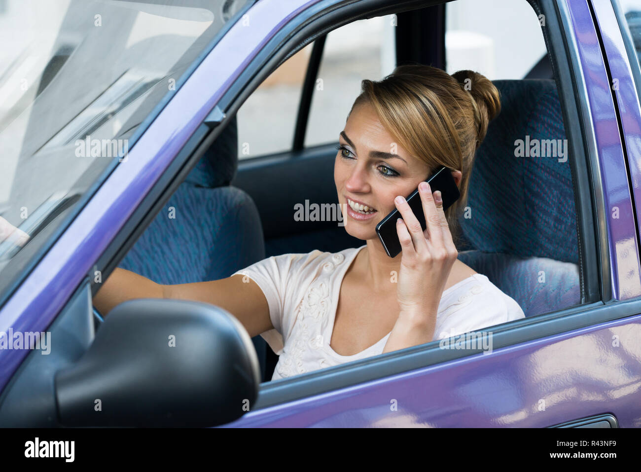 Woman Using Mobile Phone While Driving Car Stock Photo - Alamy