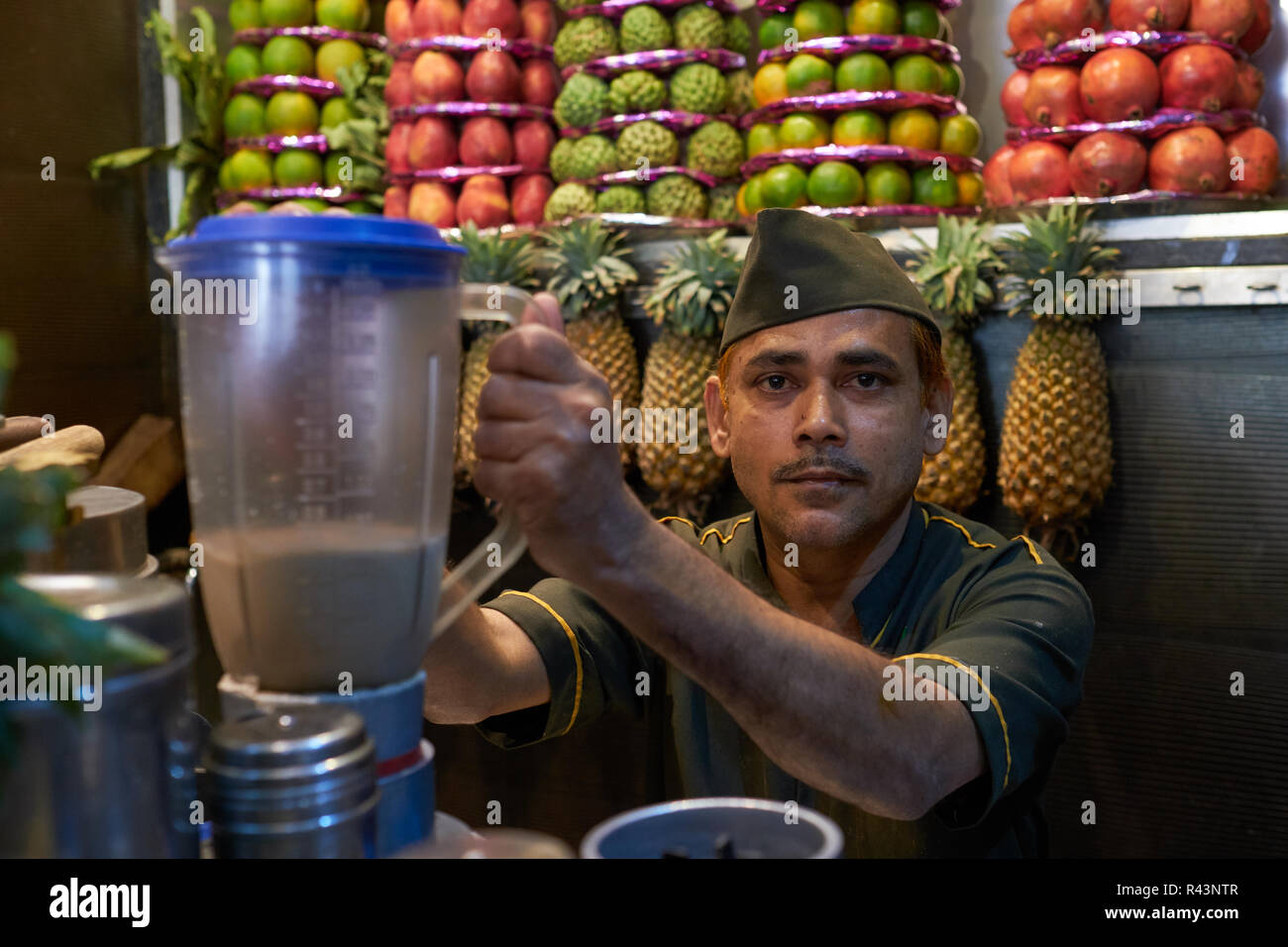 A employee at Badshah Cold Drink House in Mumbai, India, mixing a ...