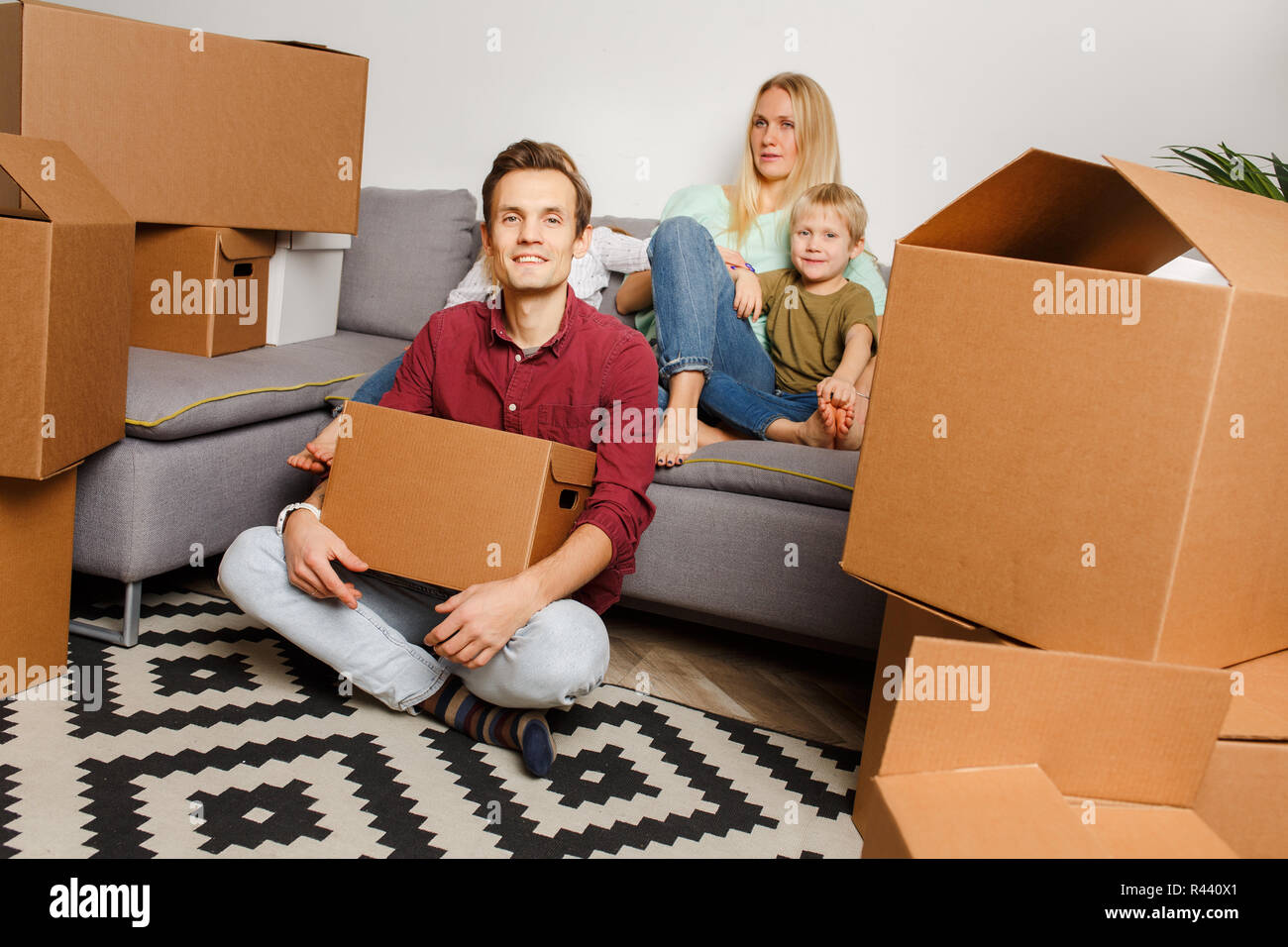 Picture of young couple with son and daughter sitting on floor among ...