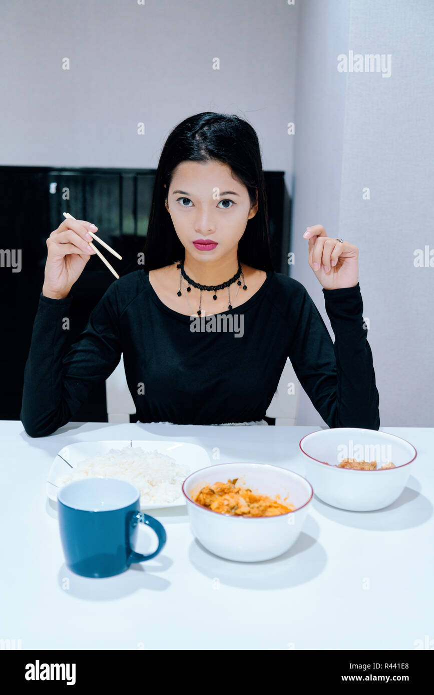 Beautiful woman posing - eating, holding chopstick, sitting Stock Photo ...