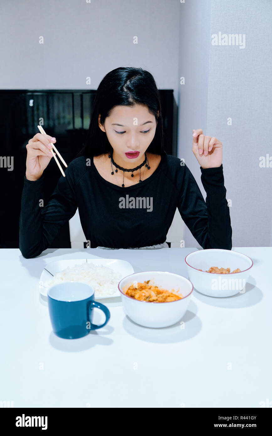 Beautiful woman posing - eating, sitting, holding chopstick, looking ...
