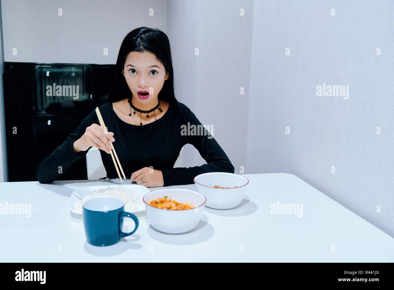 Beautiful woman posing - eating, picking rice, shocked Stock Photo - Alamy