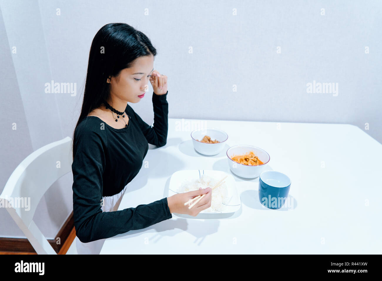 Woman alone eating rice hi-res stock photography and images - Alamy