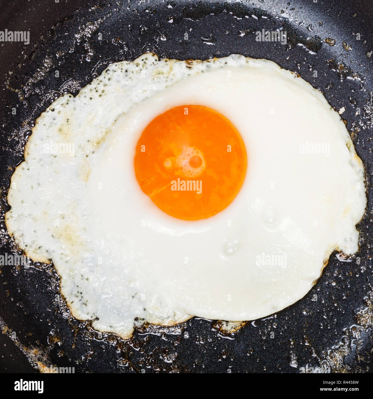 top view of one fried egg in black frypan Stock Photo - Alamy