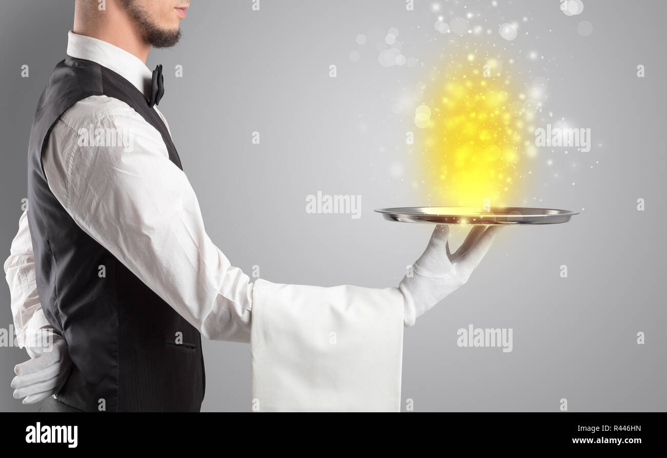 Elegant young waiter serving mysterious light on tray Stock Photo - Alamy