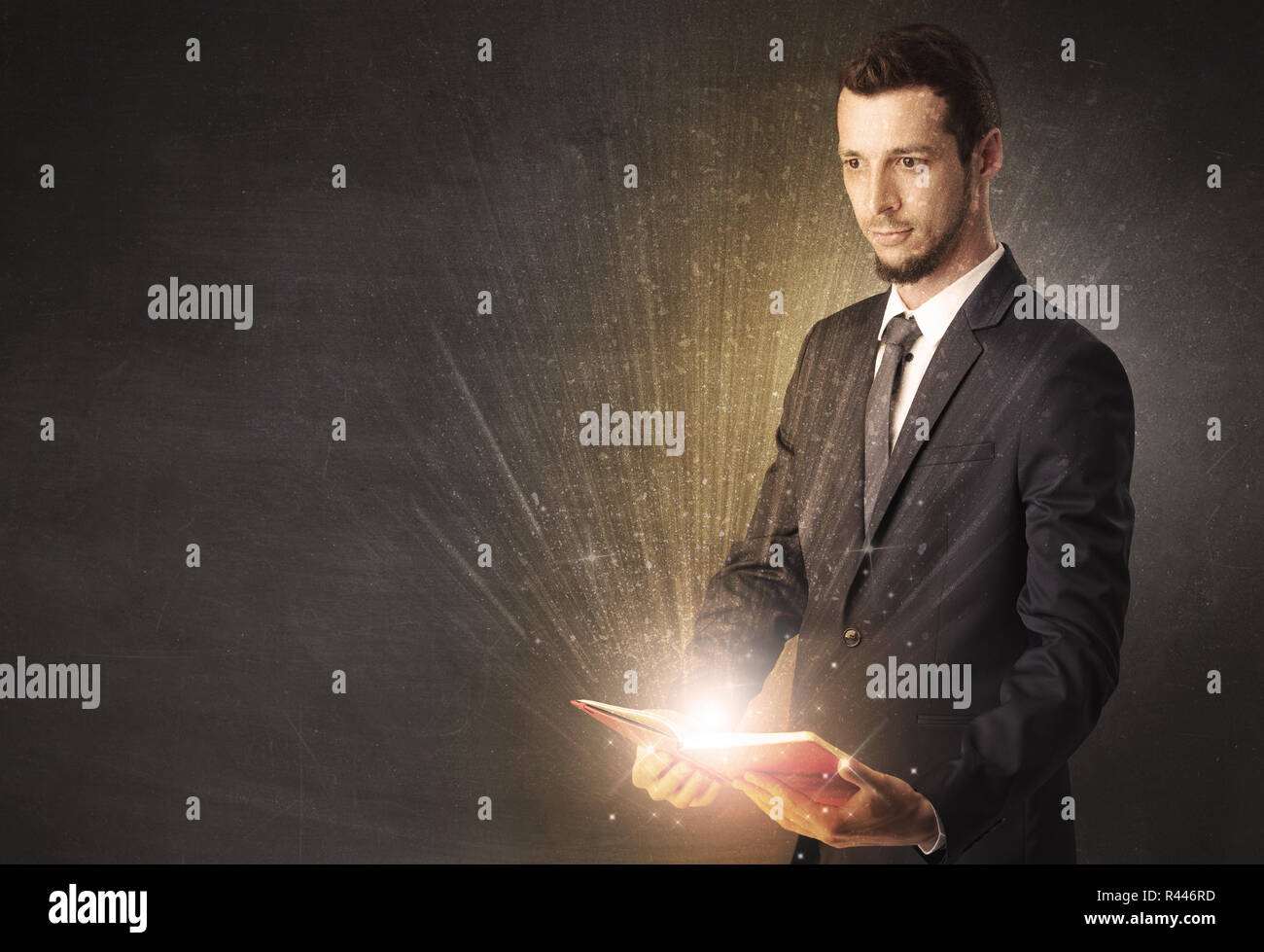 Man holding and reading a shiny book Stock Photo - Alamy