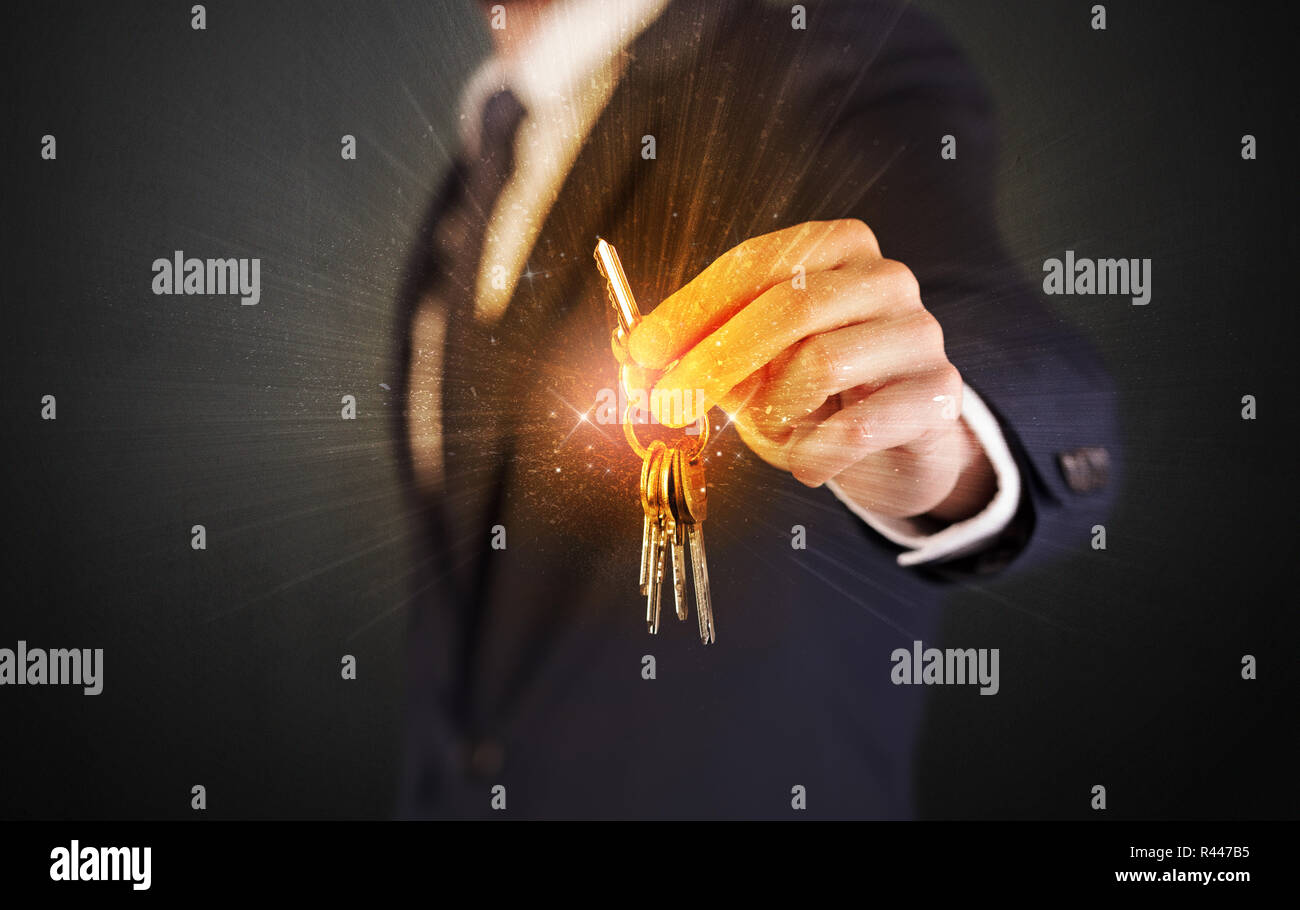 Formal man hand over shiny keys with dark background Stock Photo - Alamy