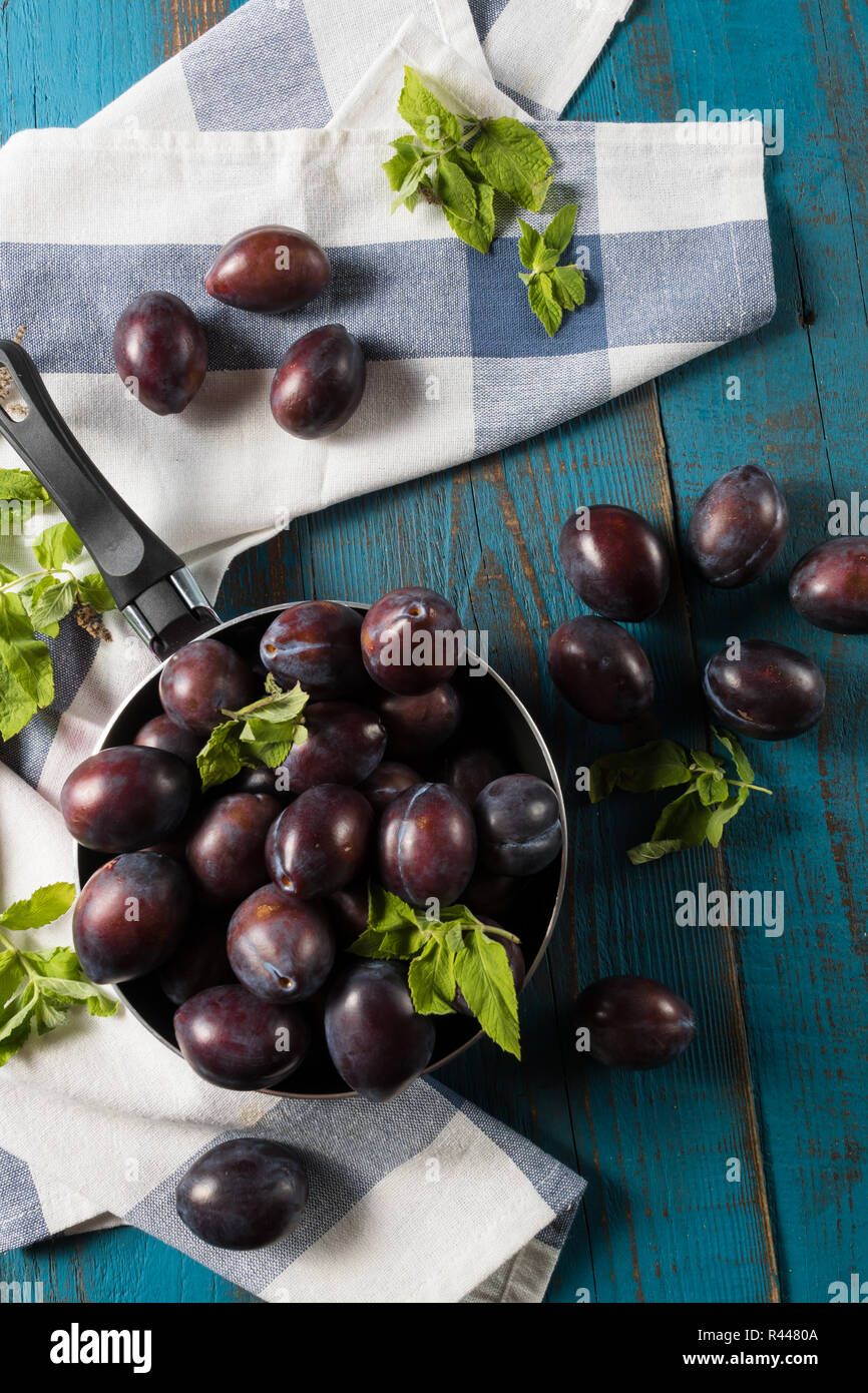 Flat lay view of ripe plums, on old wooden white background Stock Photo ...