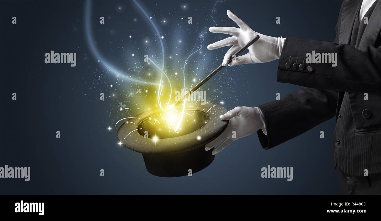 Magician hand conjure with wand light from a black cylinder Stock Photo ...