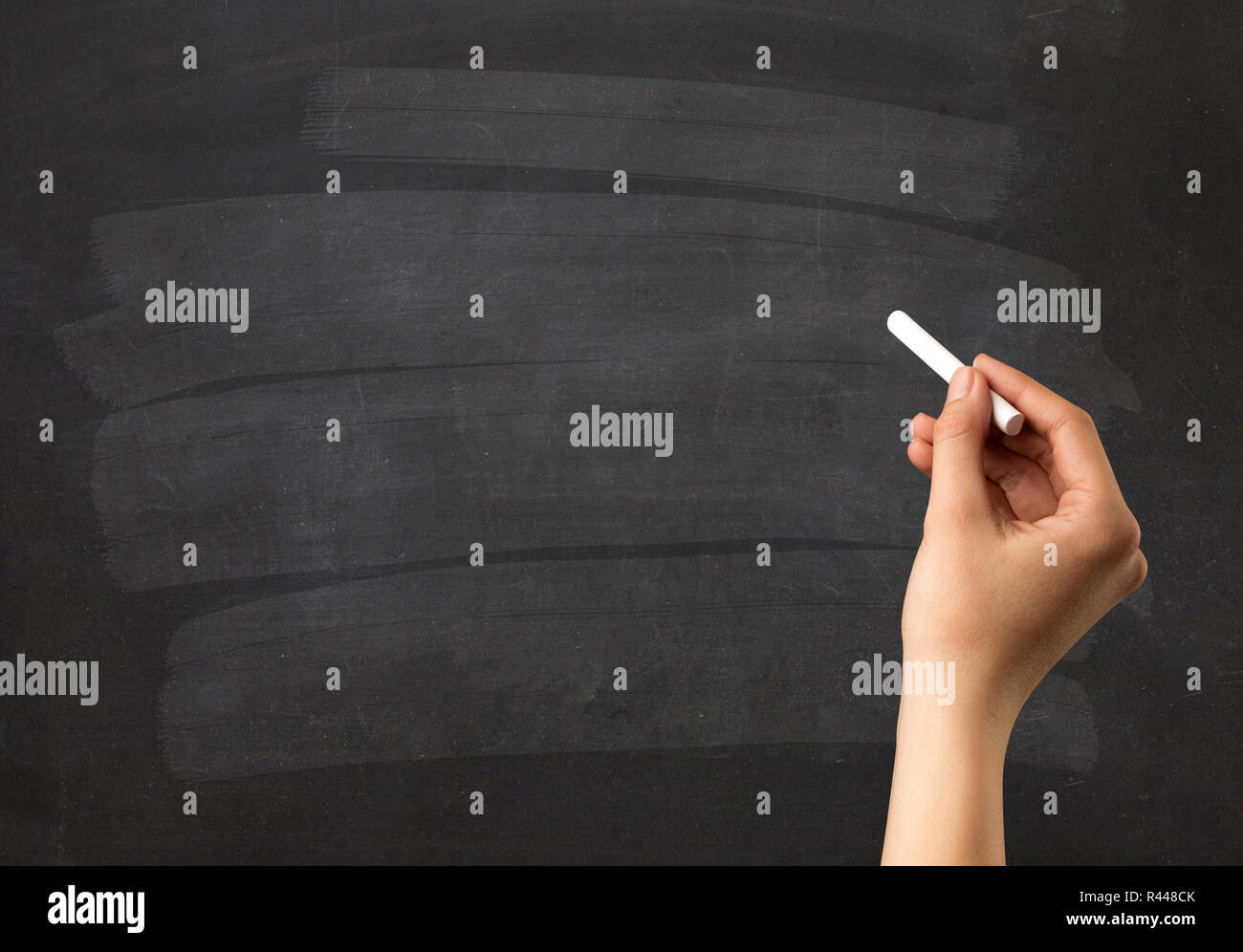 Female hand holding white chalk in front of a blank blackboard Stock ...