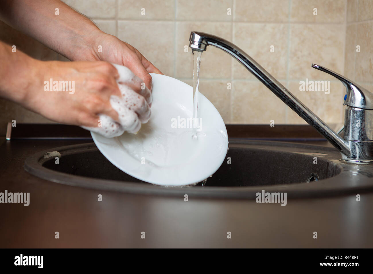 Image of side of man washing white plates Stock Photo - Alamy