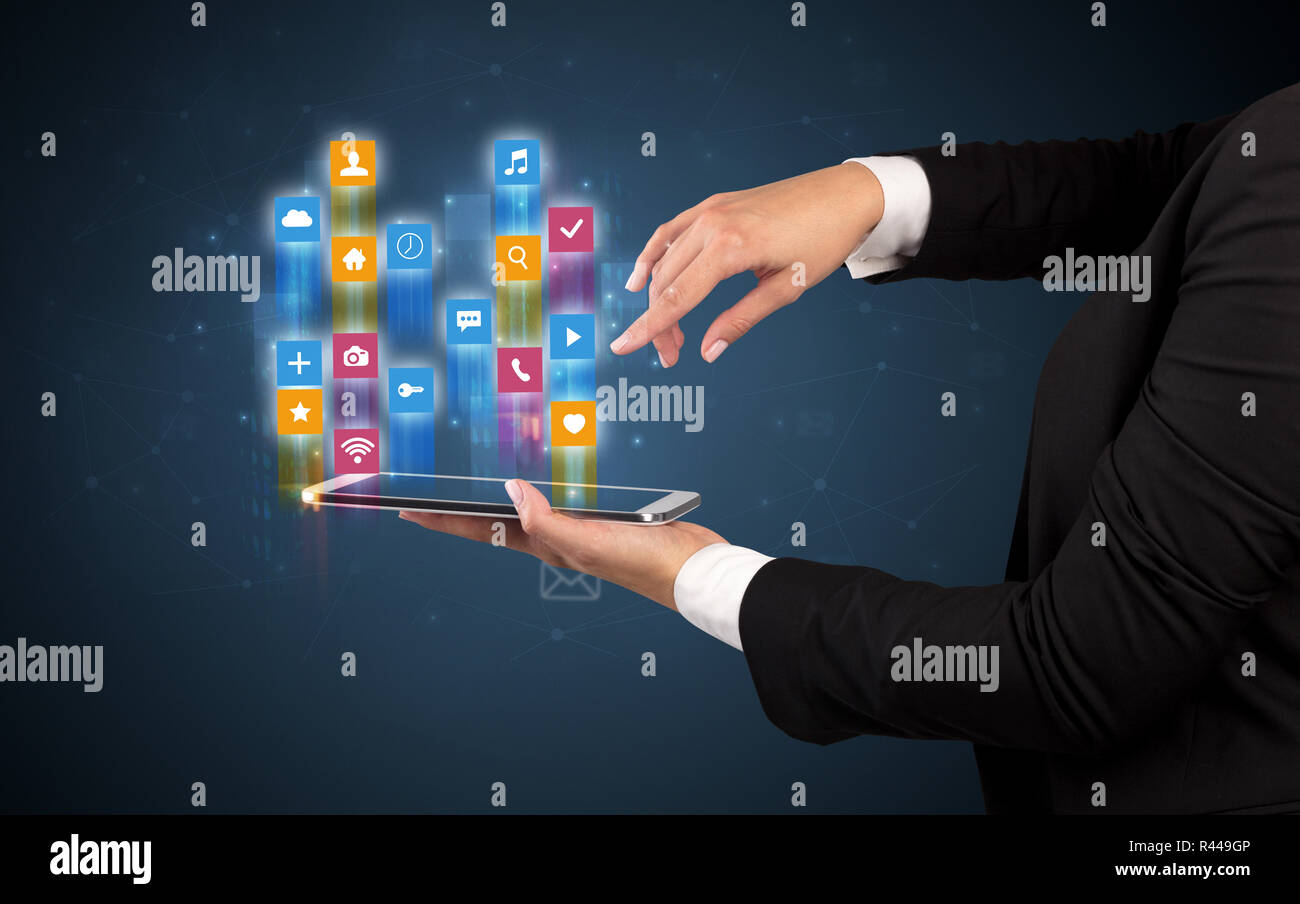 Female elegant hand holding tablet with colourful application icons ...