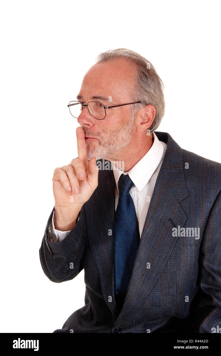 Businessman giving sign with finger over mouth Stock Photo - Alamy