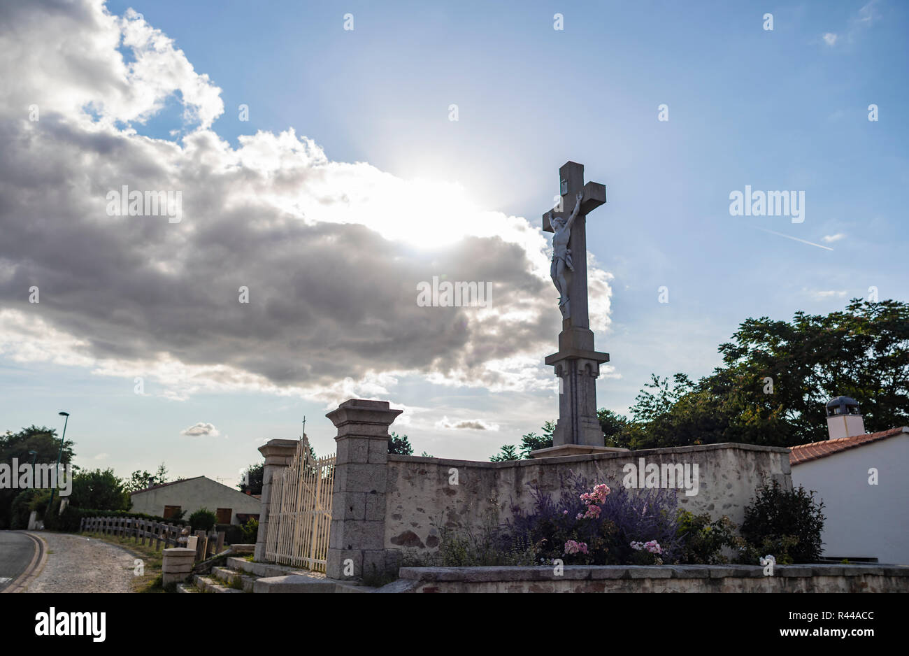 Statue of Jesus on a cross with bright sun light and rays coming ...