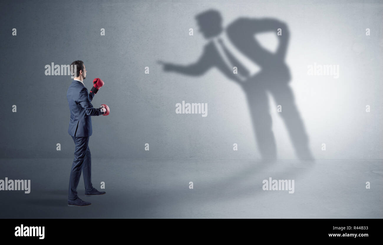 Businessman fighting with his bossy yelling shadow Stock Photo - Alamy
