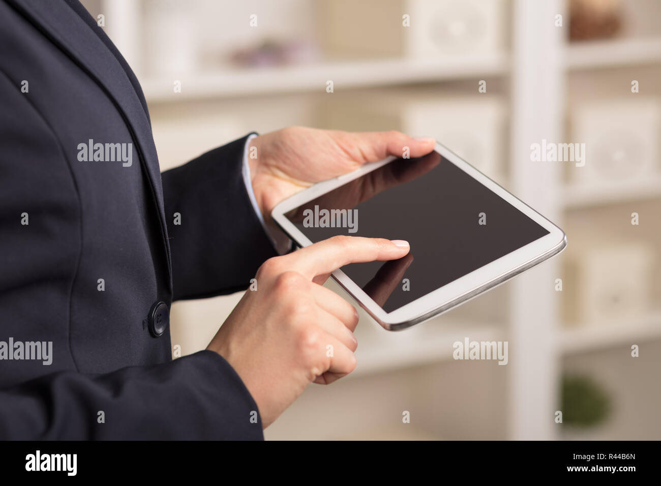 Business woman below chest using tablet in a homey environment Stock ...