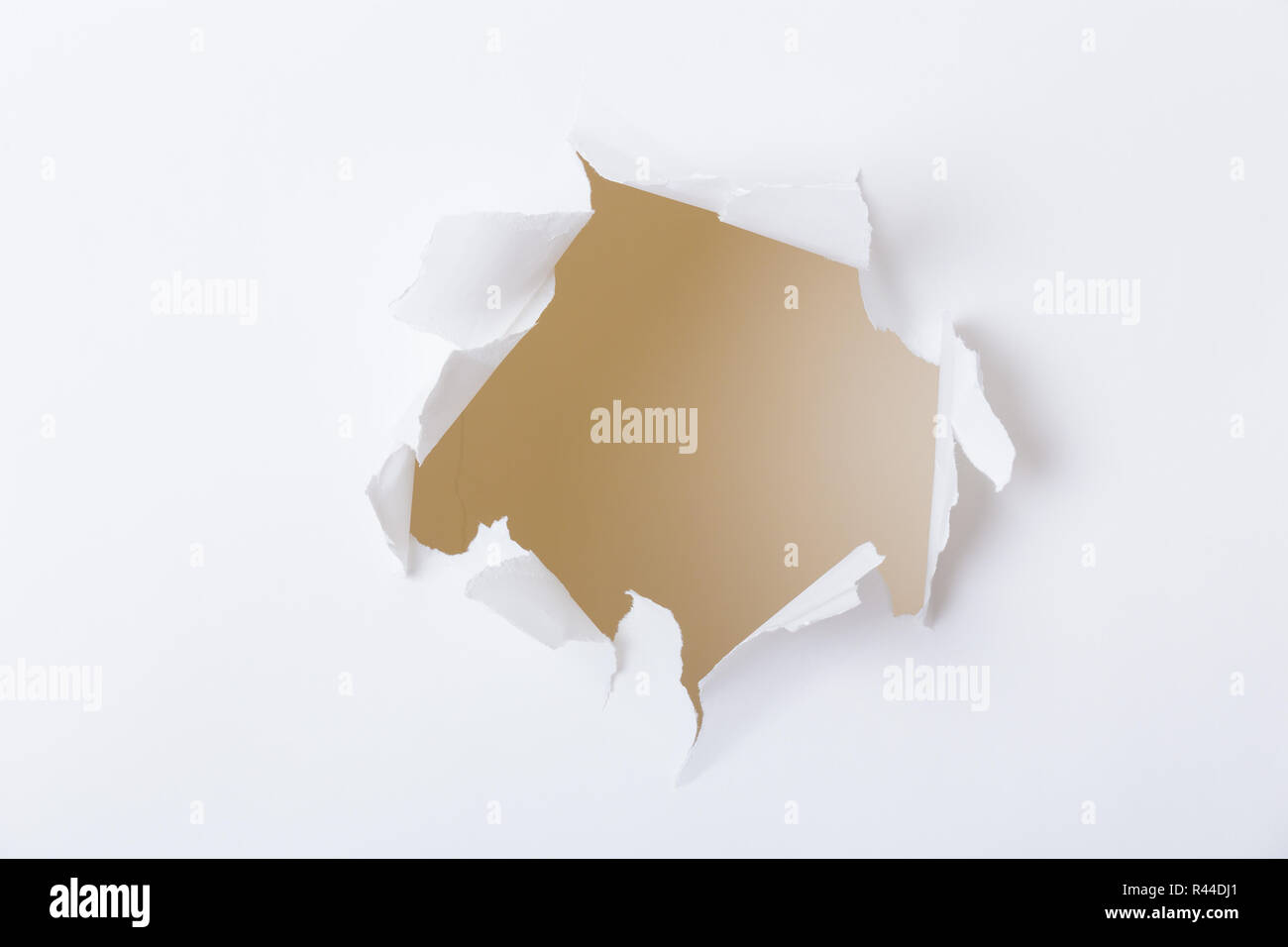 Hole in the paper with torn Stock Photo - Alamy