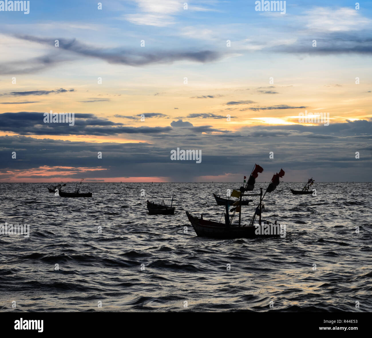 Dramatic sunset sky on the sea with fishing boat Stock Photo - Alamy